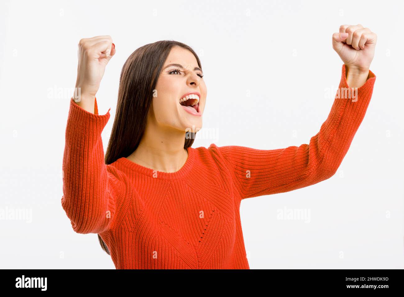 Beautiful and happy woman with arms up, isolated over white background ...