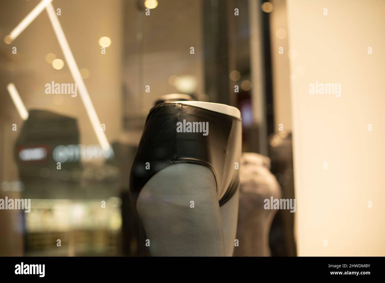 Women's mannequin shopping mall. Window of clothing store. Dummy of leg ...