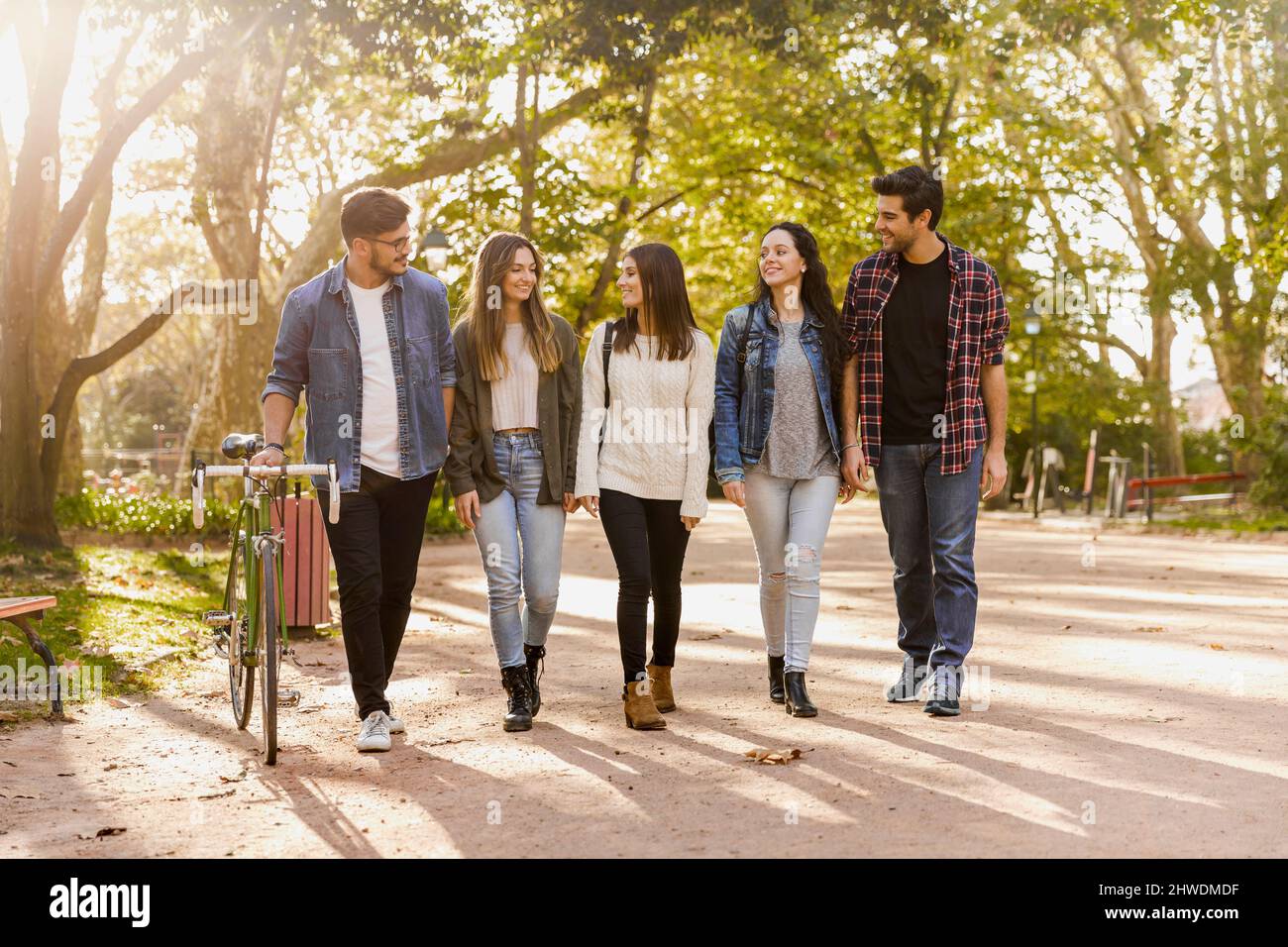 Group of students walking together in the park Stock Photo - Alamy