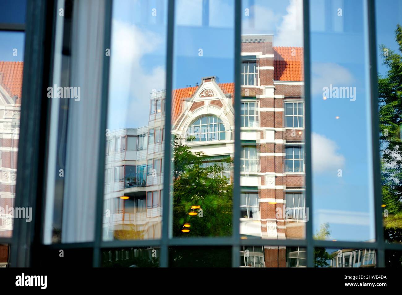 Typical Dutch house reflecting in the window of residental building in ...