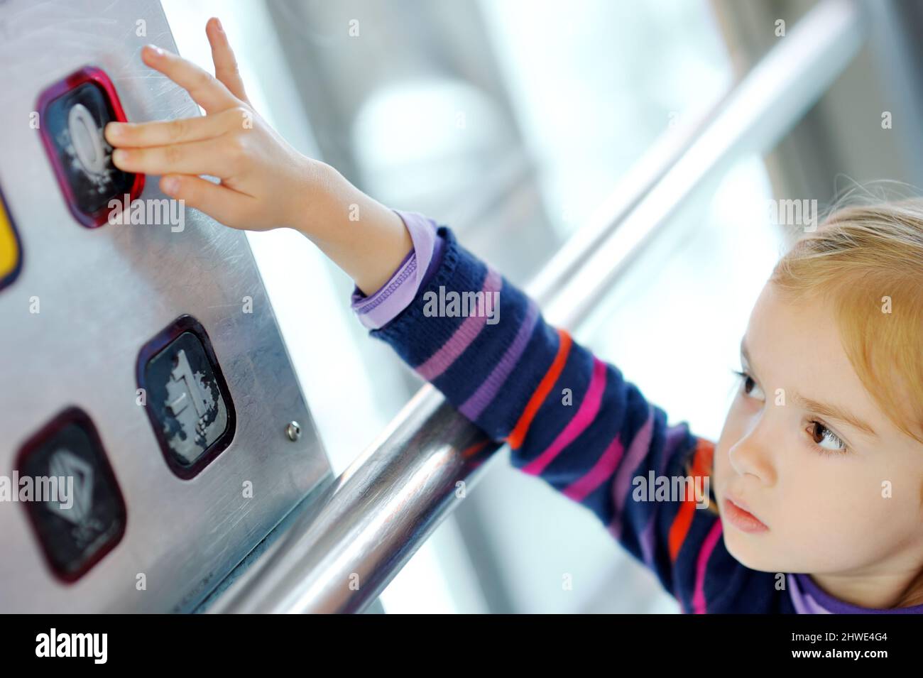 Cute little girl pressing elevator button with her finger. Child ...