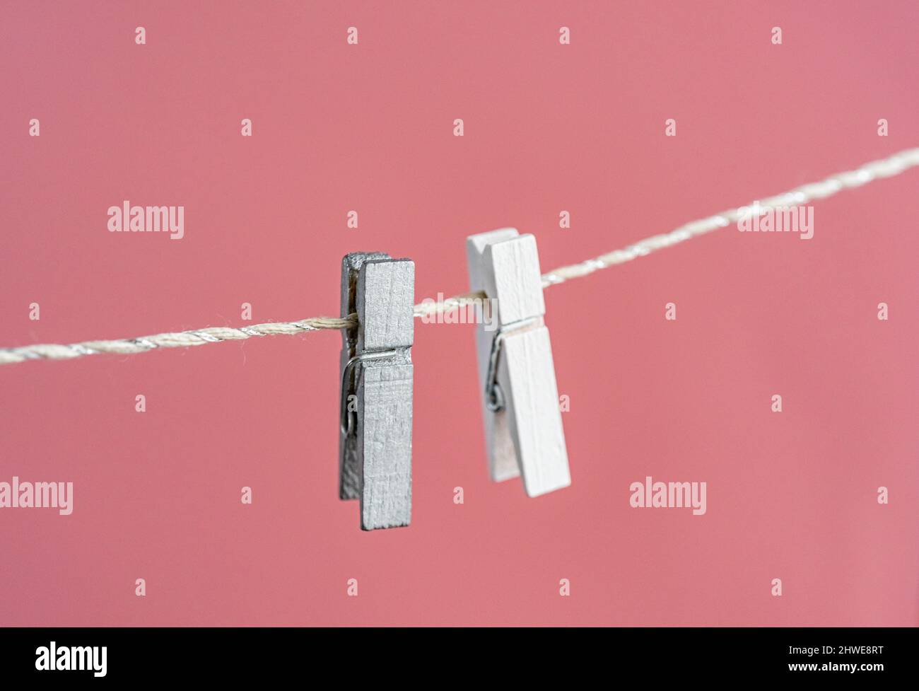 Two grey and white clothes pins on a clothes line rope holding nothing ...