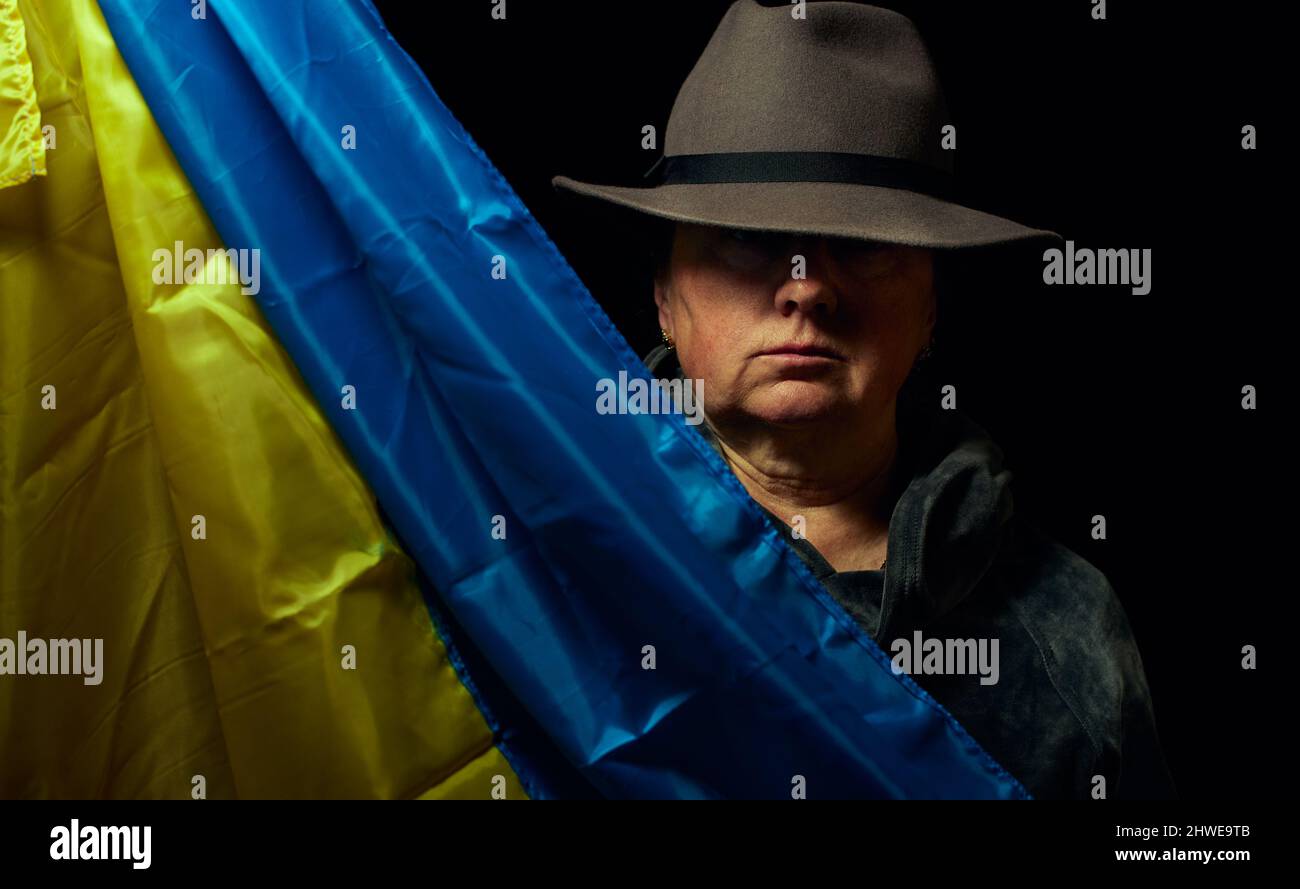 Anonymous woman with Ukrainian flag with black background. Stop war in ...