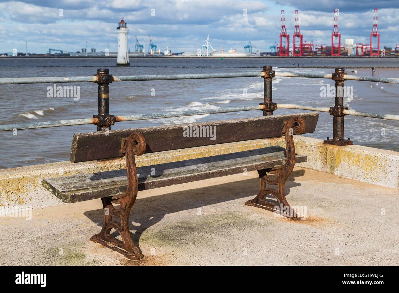 A weathered bench seen on the promenade at New Brighton facing out over ...