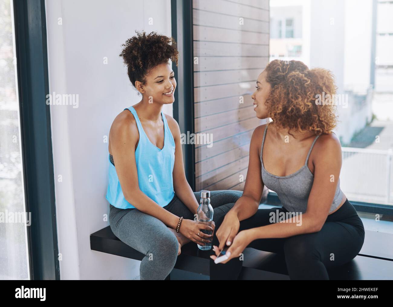 Catching up after yoga class. Cropped shot of two young women talking ...
