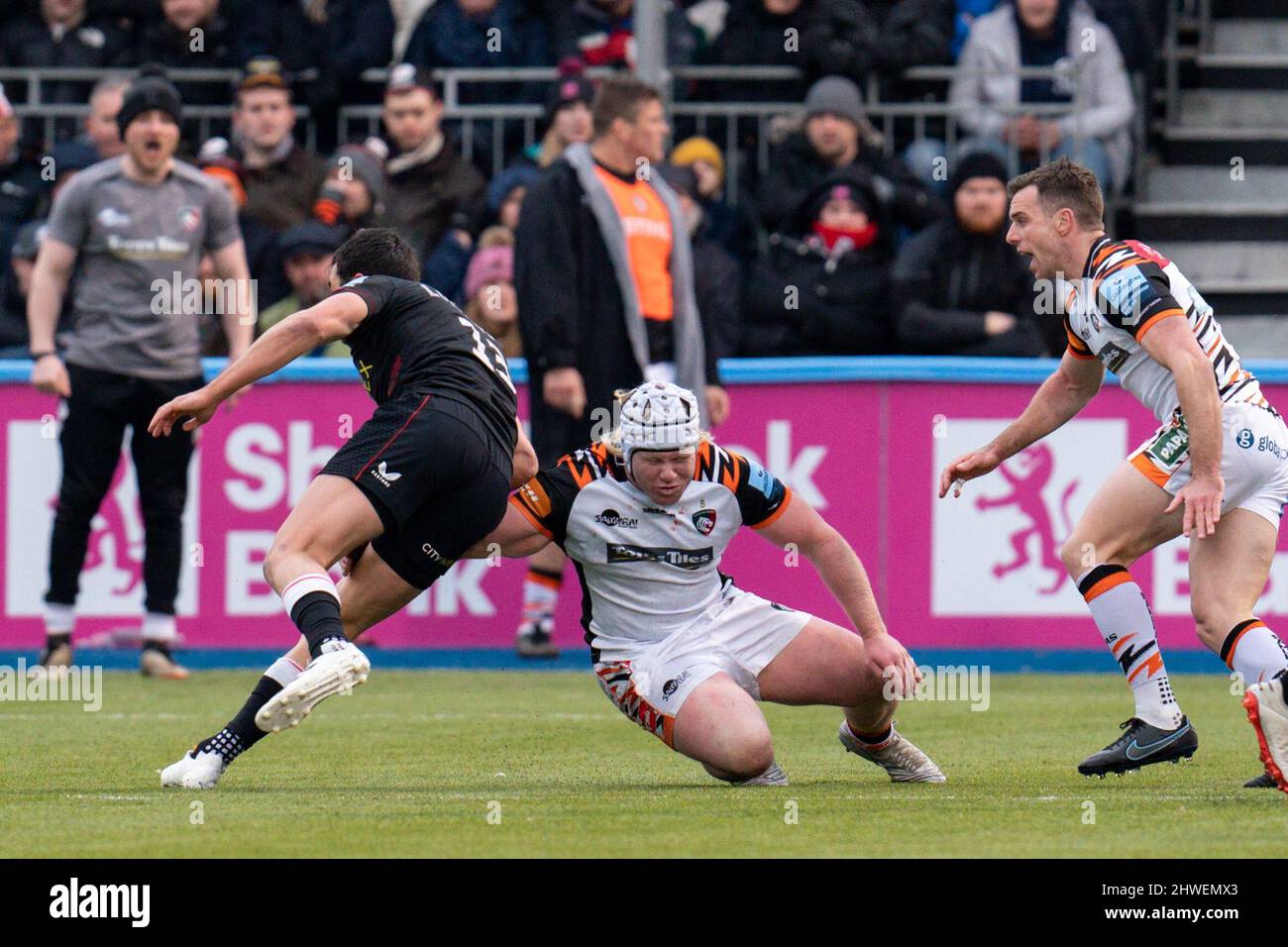 Alex Lozowski #13 of Saracens tries to get round Nic Dolly #2 of ...