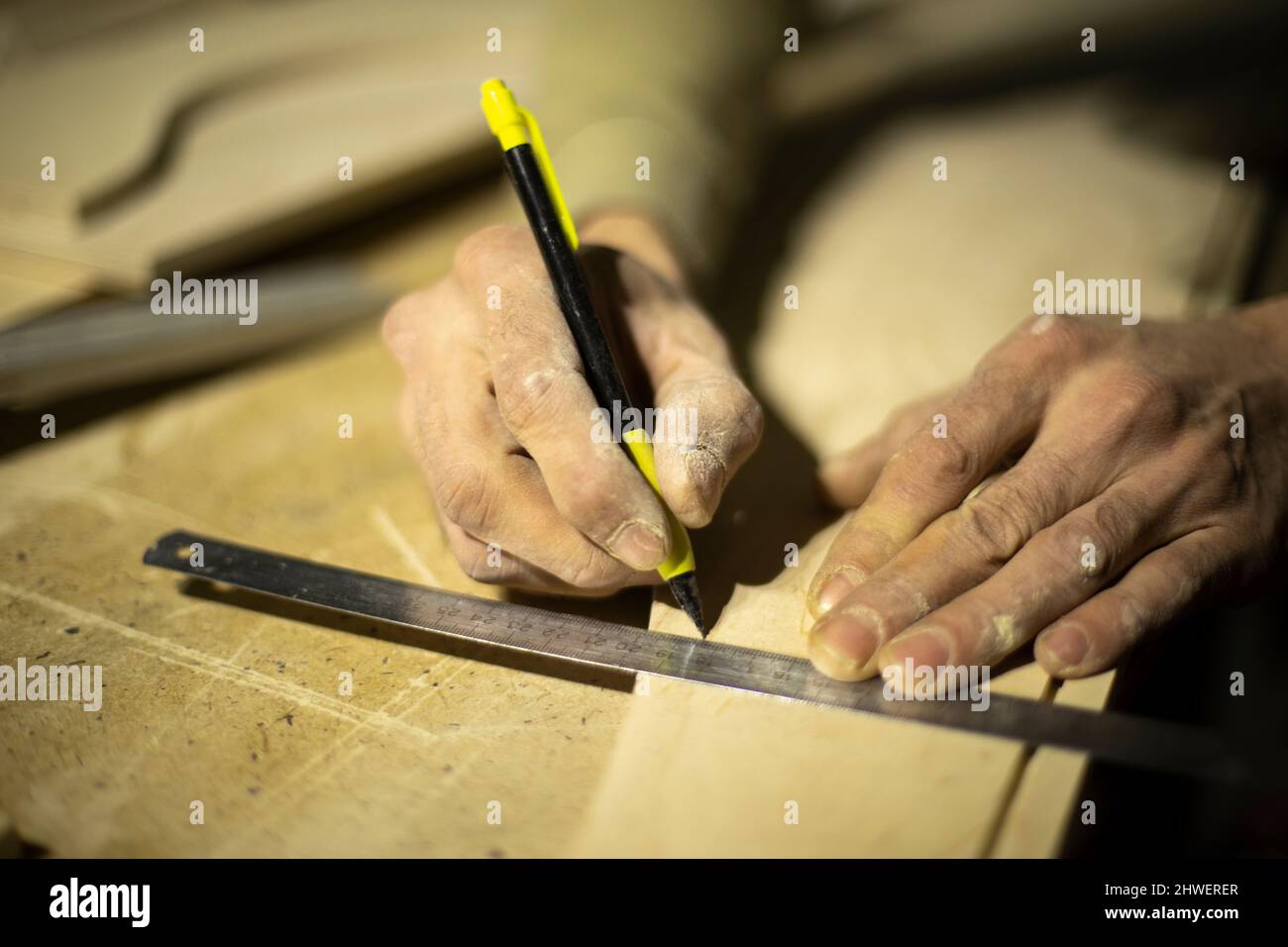 Marking on ruler with pencil. Drawing line on tree. Hands of carpenter ...