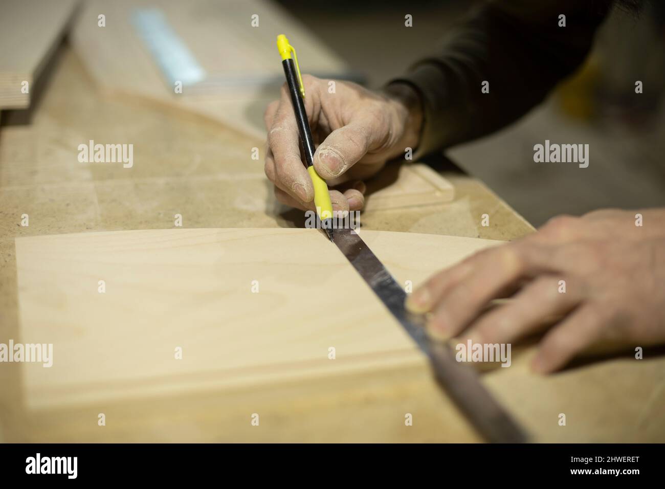 Marking on ruler with pencil. Drawing line on tree. Hands of carpenter ...