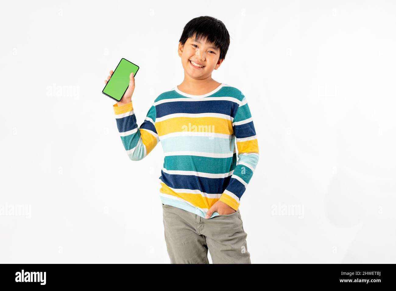 Young Asian Kid holding a phone in his hands with a green screen ...