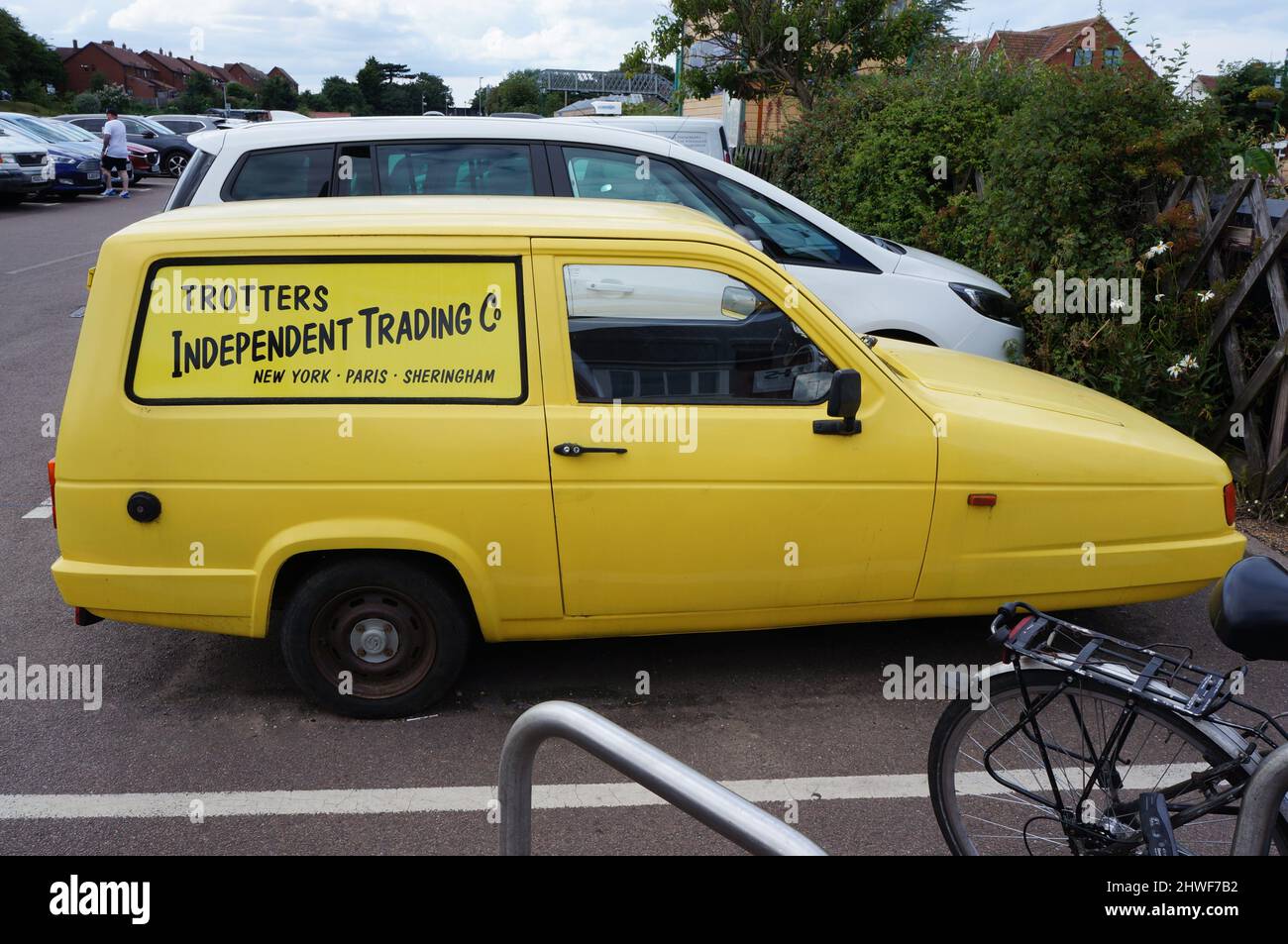 Yellow Reliant Robin 3 wheeler van in a parking lot with Trotter`s ...