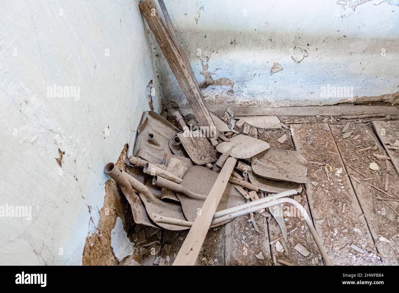 old rusty neglected spade heads and spades in the corner of the shabby ...