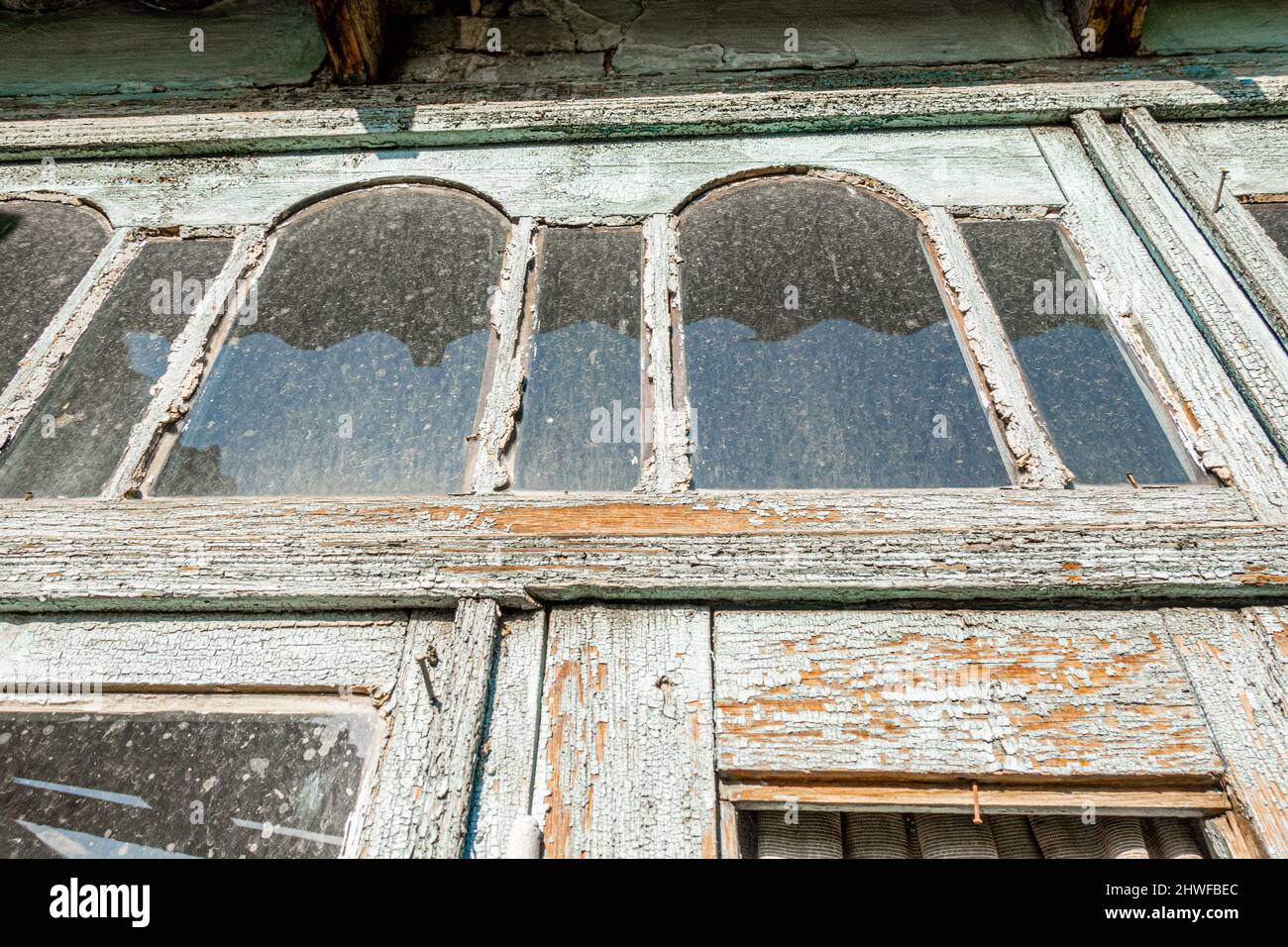 Small framed dusty window o na disintegrated wall with traditional ...