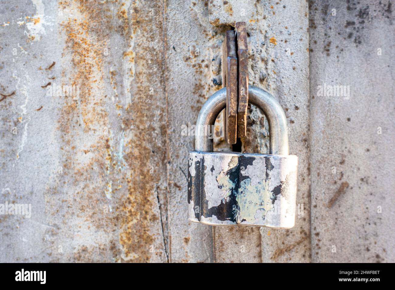 Simple metal typical Soviet Russian metal barn lock locked with peeled ...