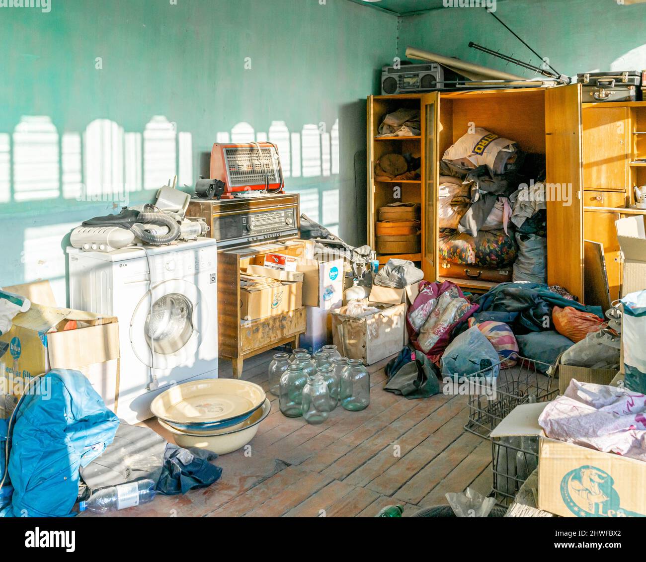 Cluttered storeroom barn with old furniture and assorted debris ...