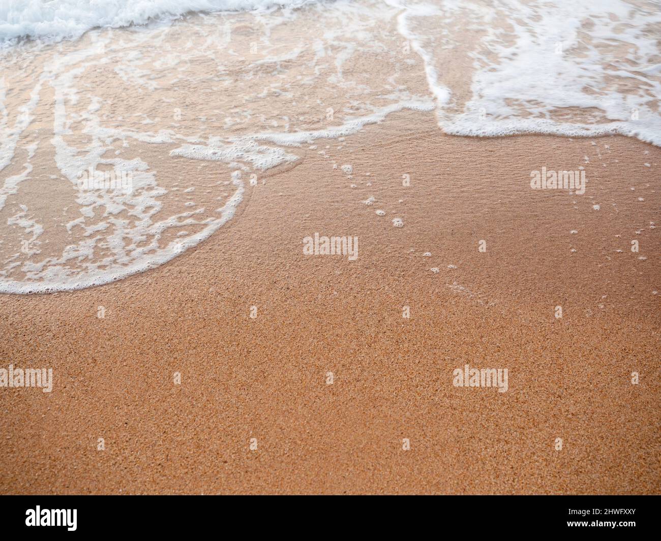 Clean sand beach background with blurred movement of splashing sea ...