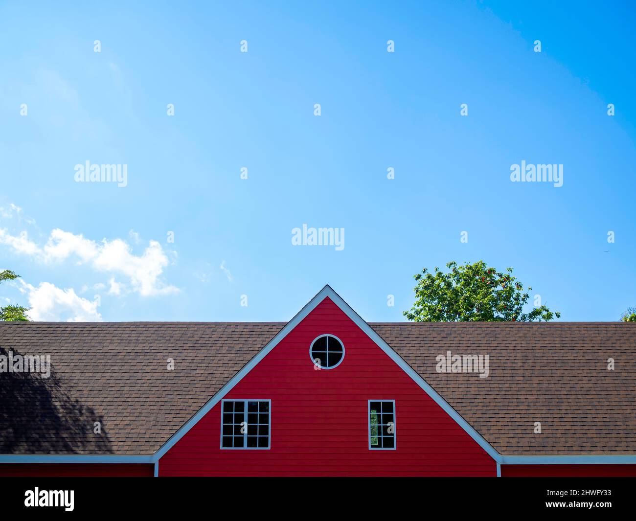 Red gable roof of big house covered with white wooden framed and ...