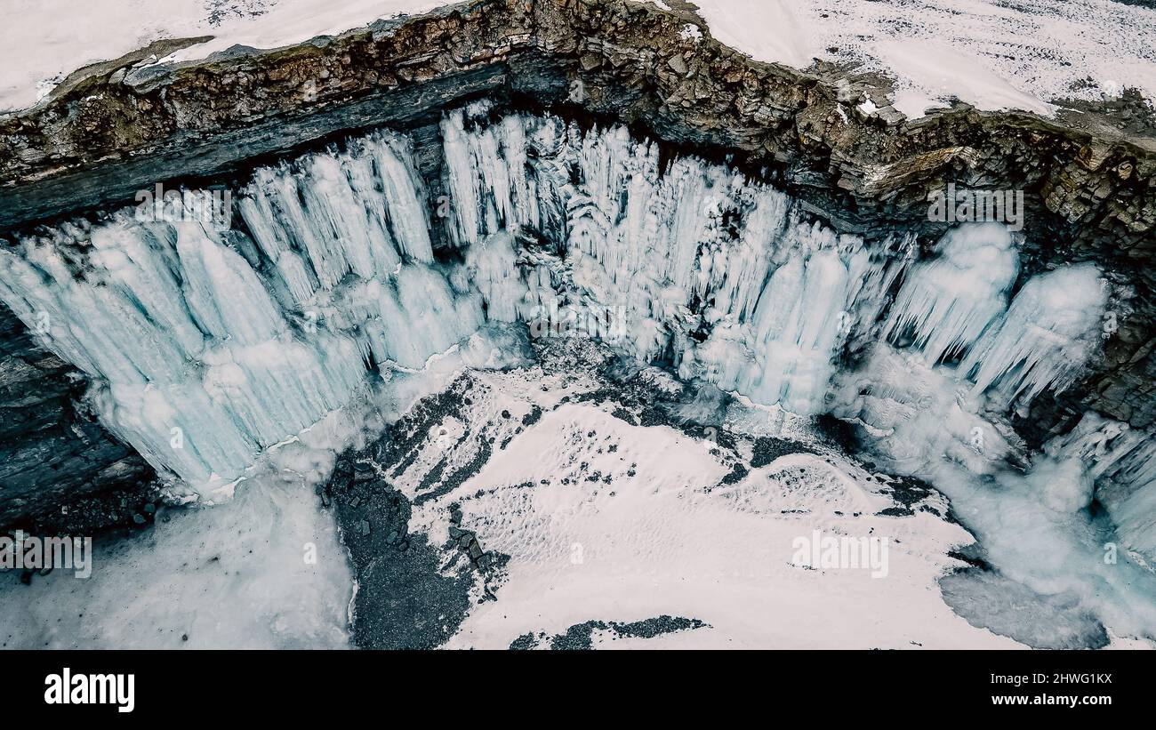 Ice and snow formations on the walls of a quarry. The snow melts on the ...