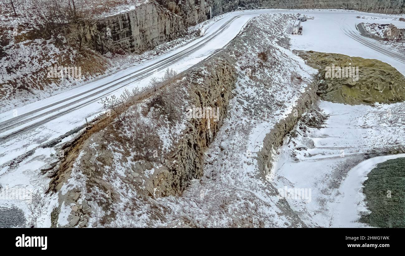 A snow covered gravel road heads down deeper into the frozen quarry ...