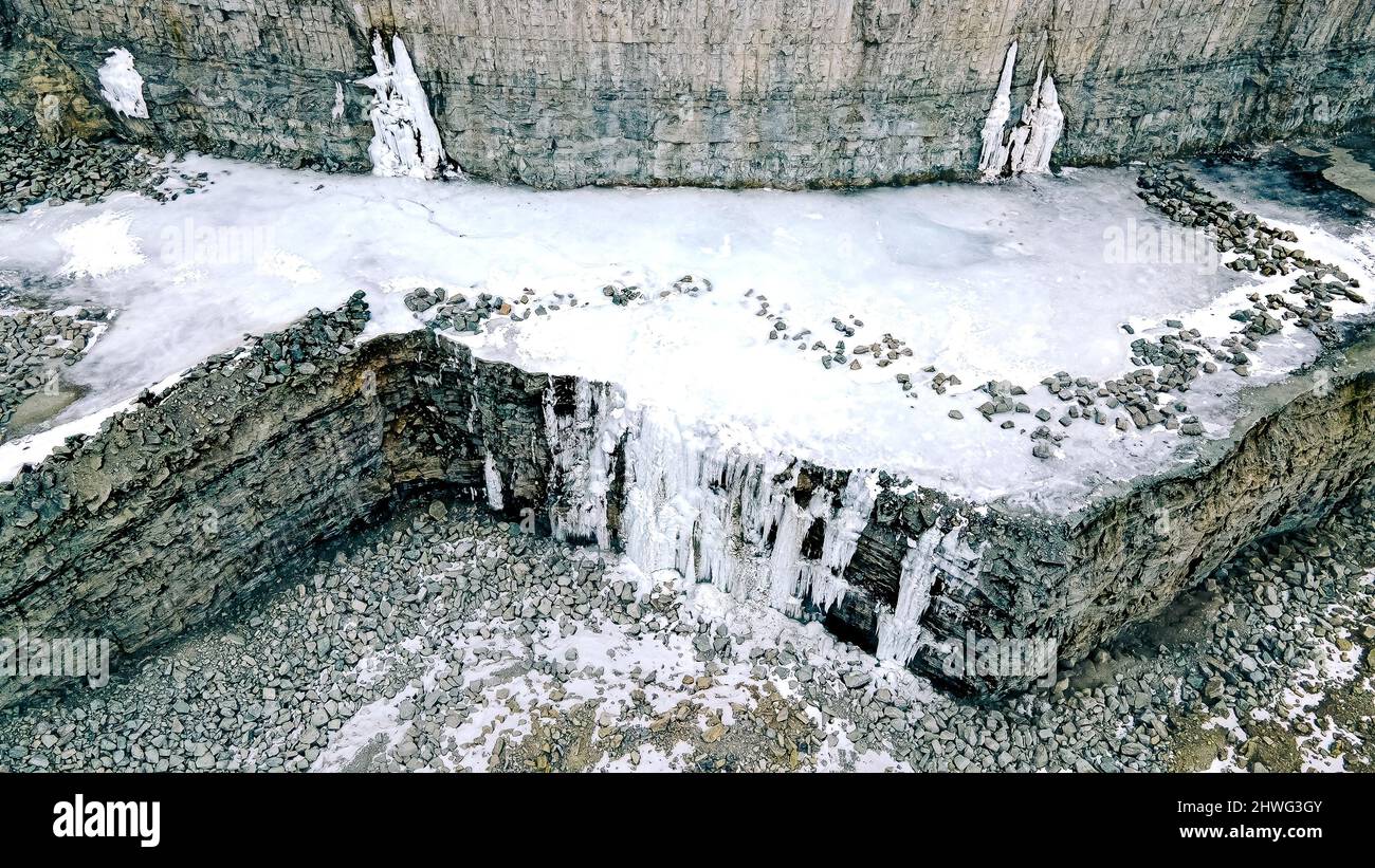 This rock quarry has a huge cut out in the ground with high cliffs ...