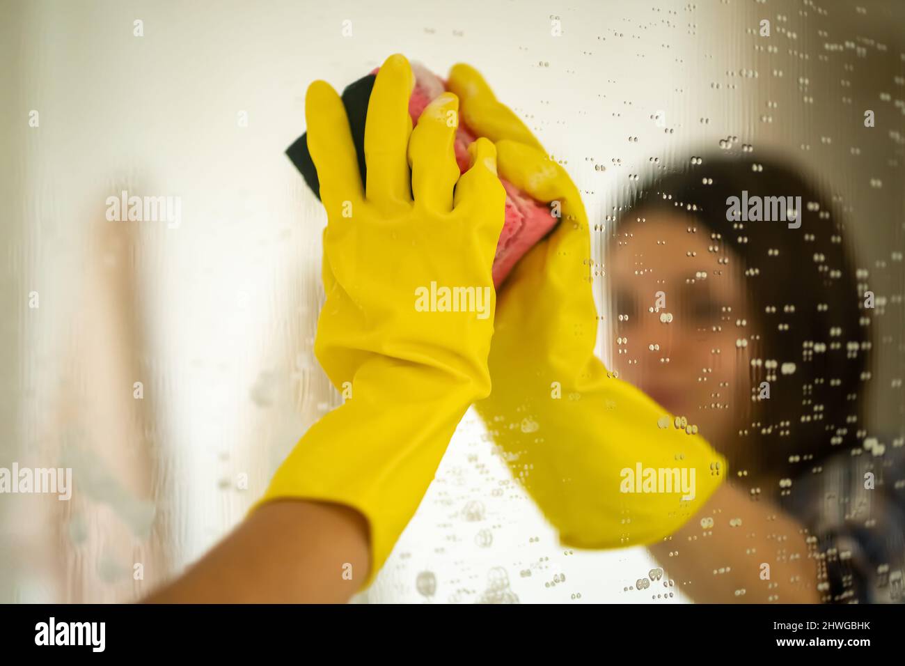 Girl is washing the mirror with a detergent Stock Photo - Alamy