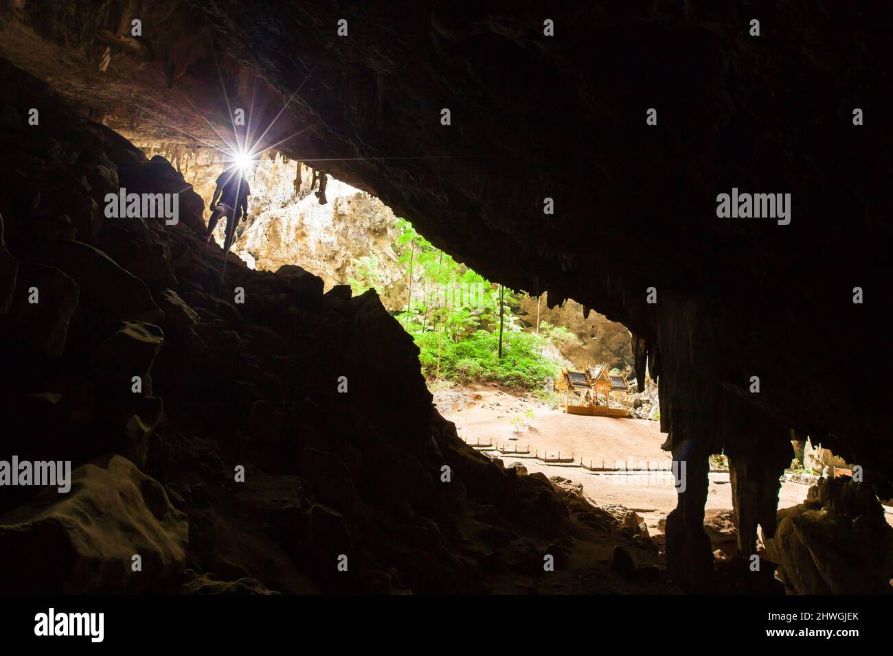 Young man explorer is exploring mystery cave with a torch, Phraya ...