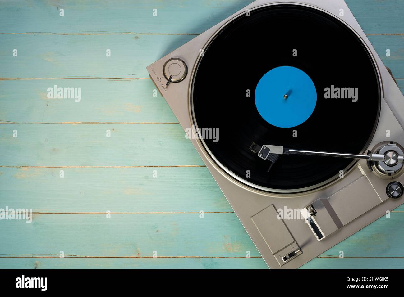 Gramophone with a vinyl record on rustic wooden table, top view and ...
