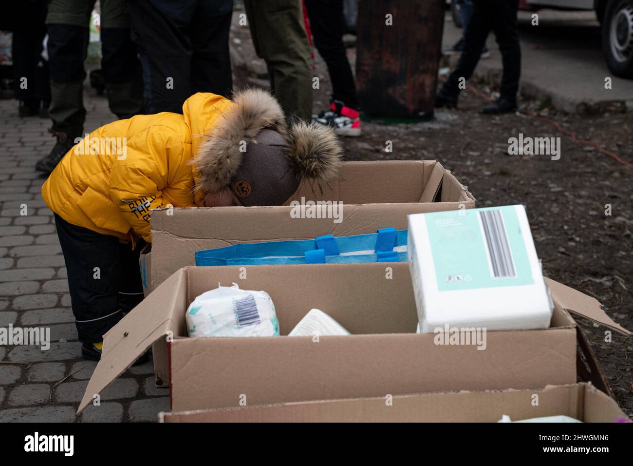 A young boy looks in a cardbox of given goods at the border checkpoint ...