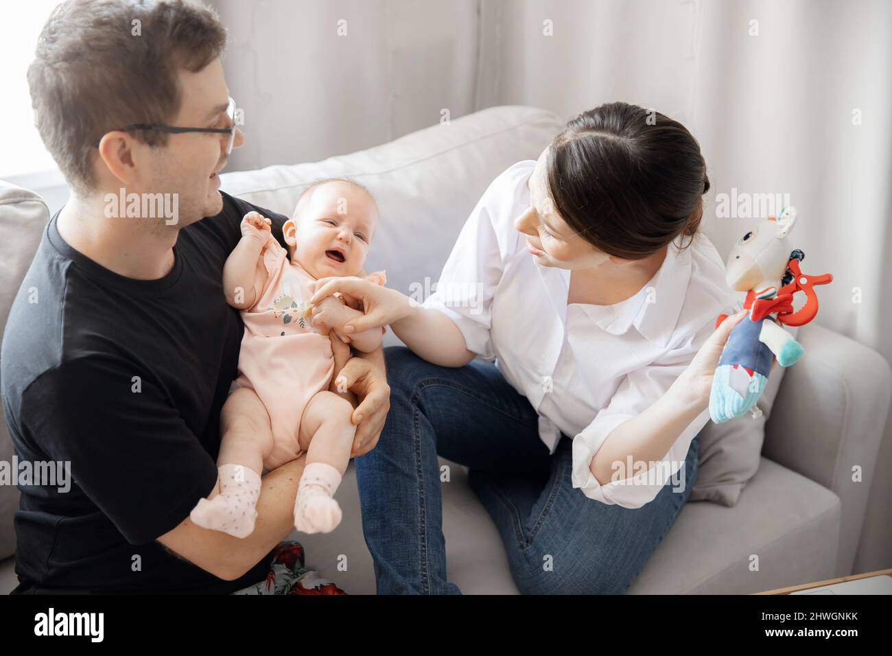 Young parents, father and mother, try to calm crying and tantrum of ...