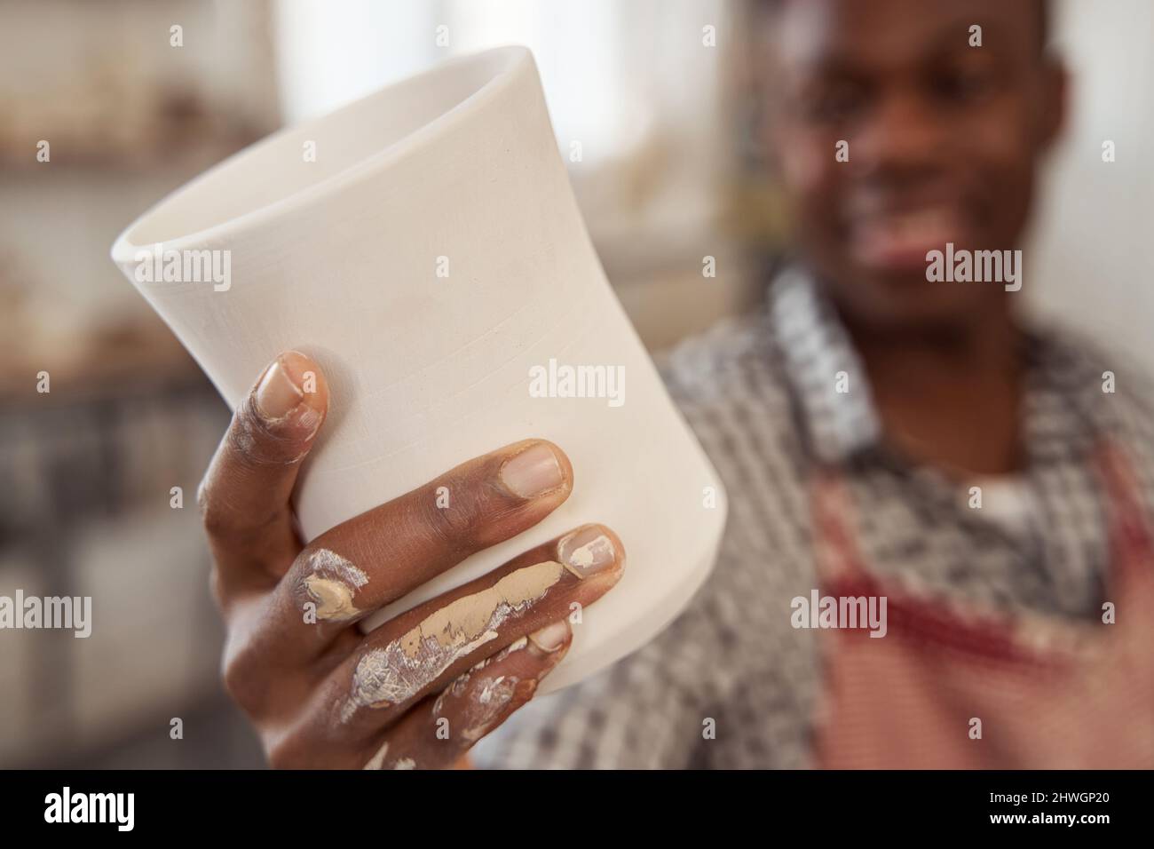 Ceramist showing his piece of pottery before camera Stock Photo - Alamy