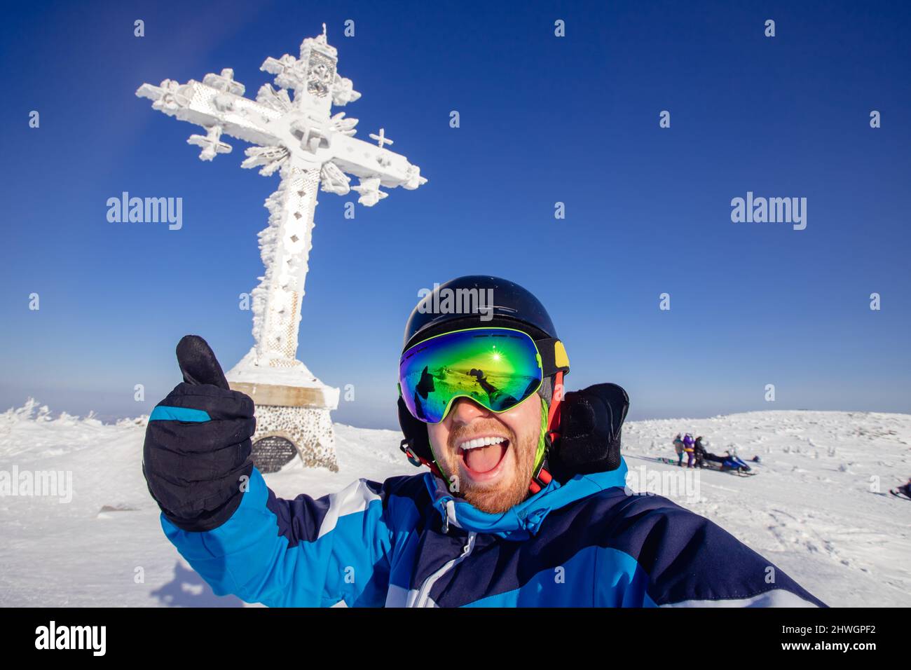 Happy skier takes selfie photo on background of worship cross on Mustag ...