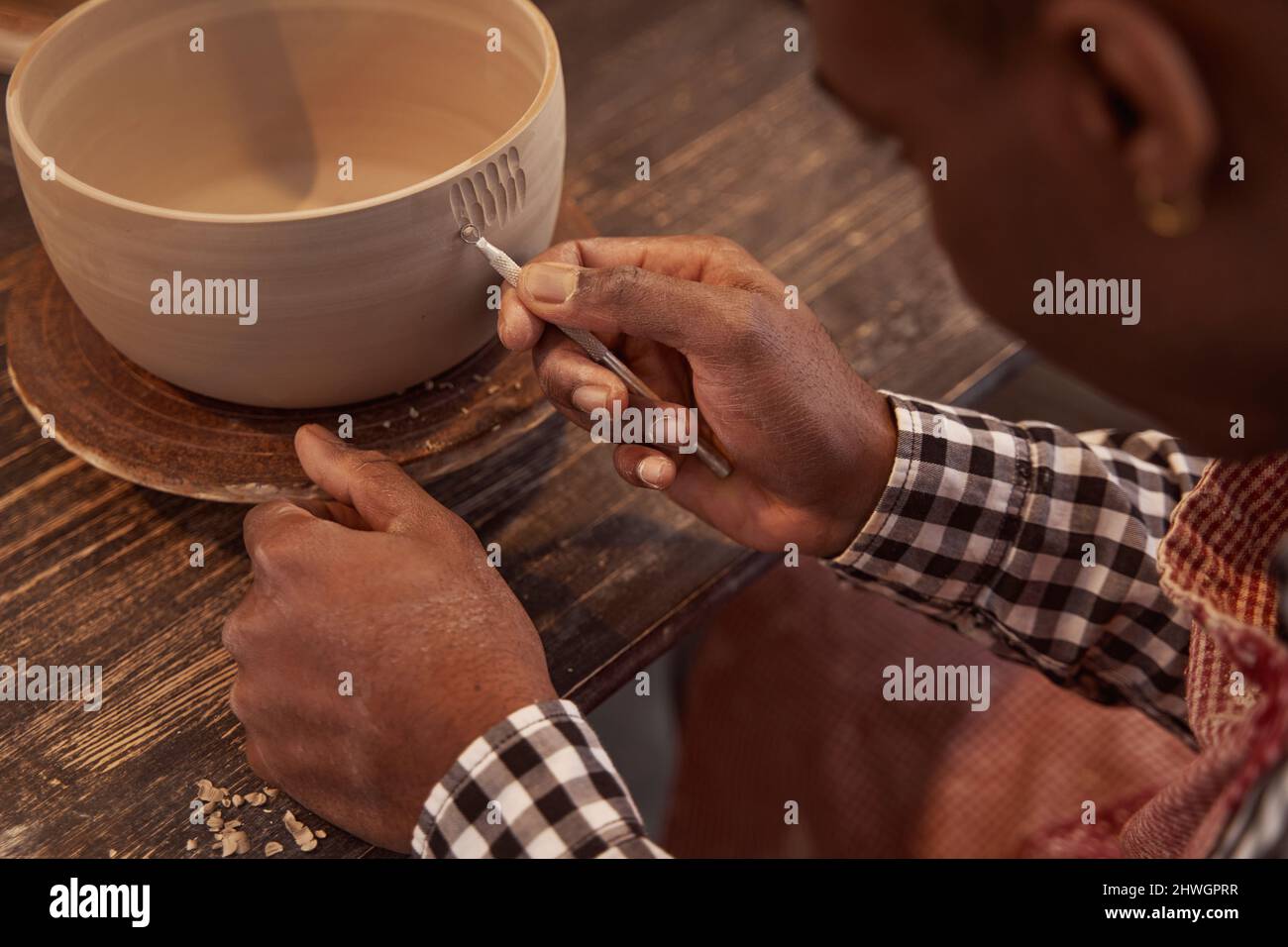 Potter making designs on piece of pottery Stock Photo - Alamy