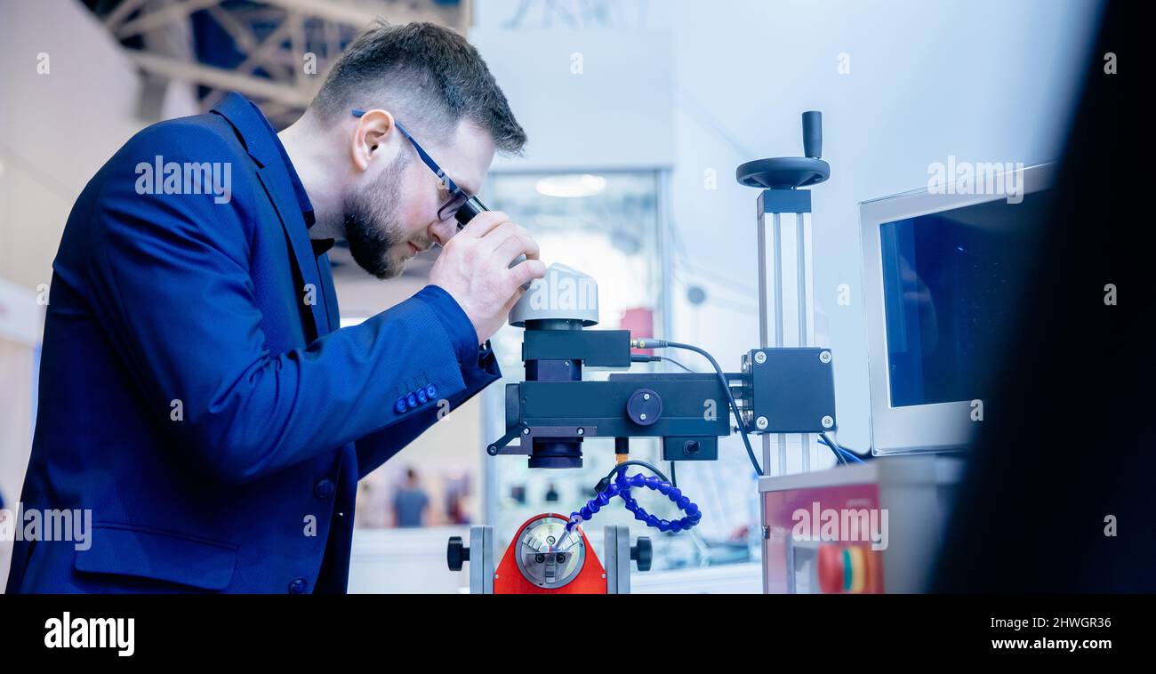 Industrial worker use microscope for precision plasma welding at modern ...