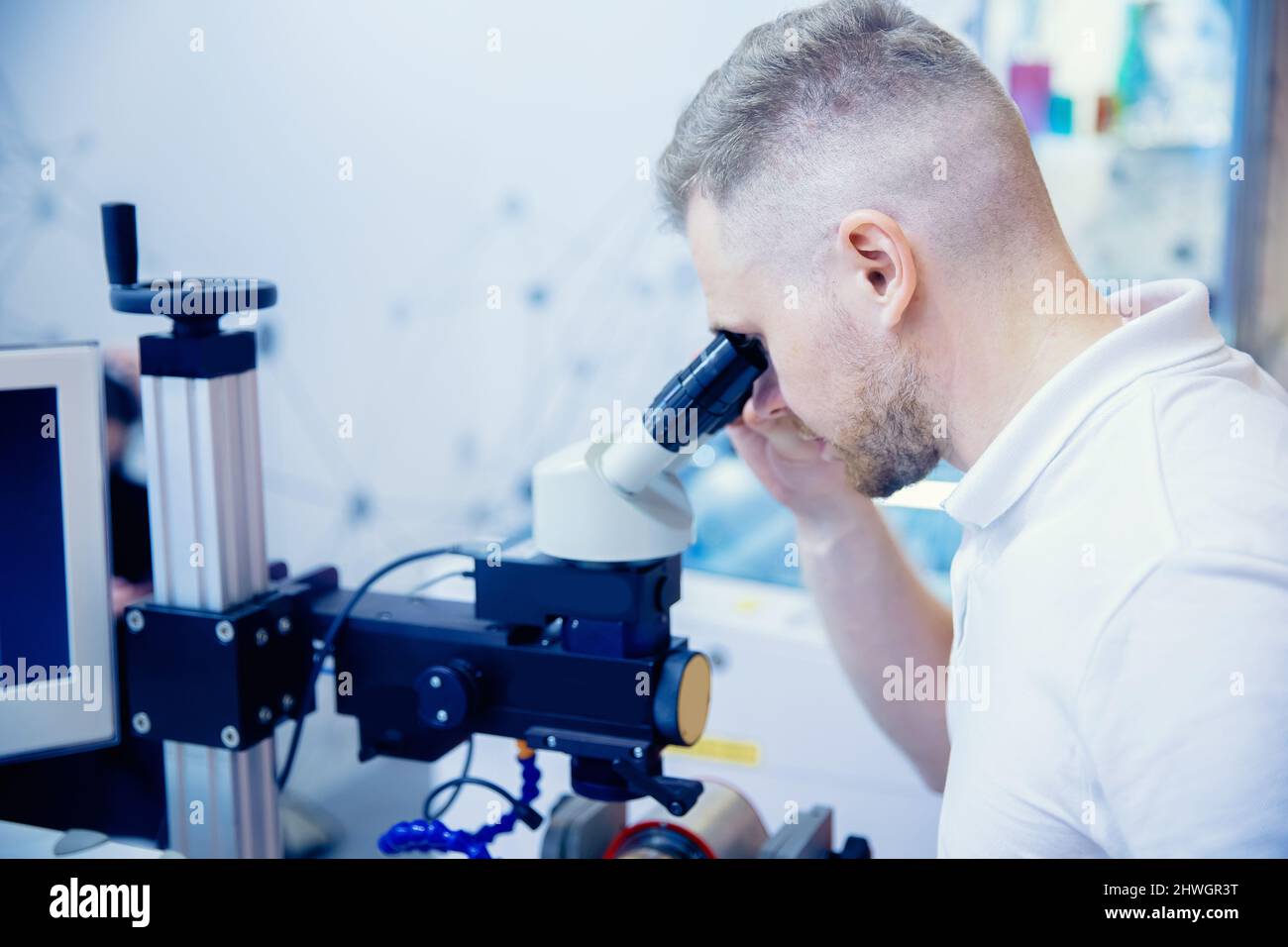 Industrial worker use microscope for precision plasma welding at modern ...