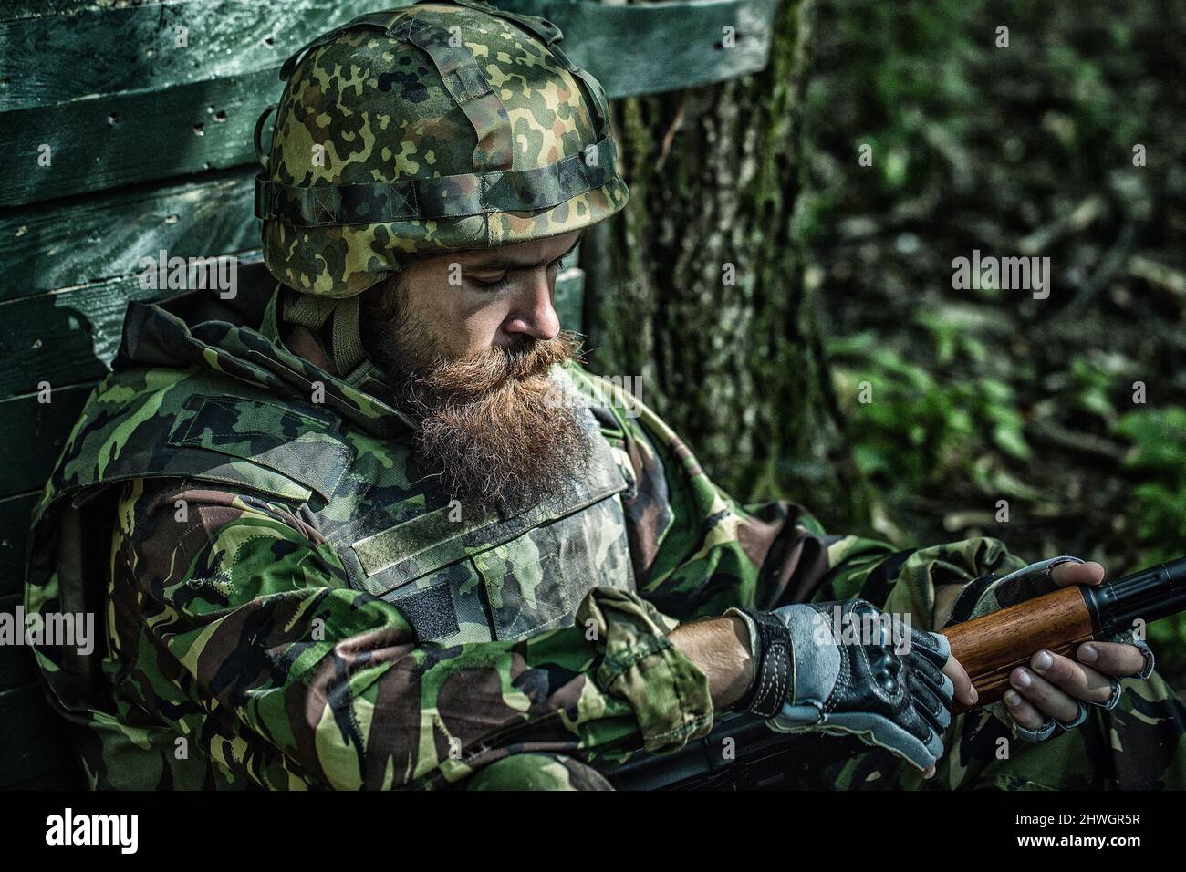 Tired soldier. Army soldier with assault rifle and combat helmet ...