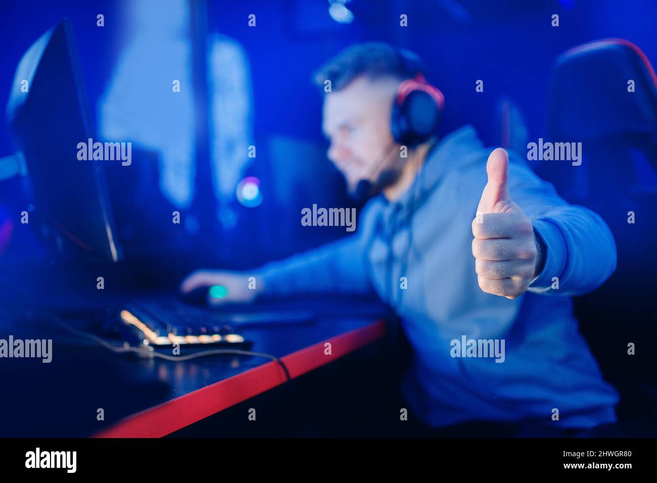 Streamer young man on chair in game studio. Gamer playing action video ...