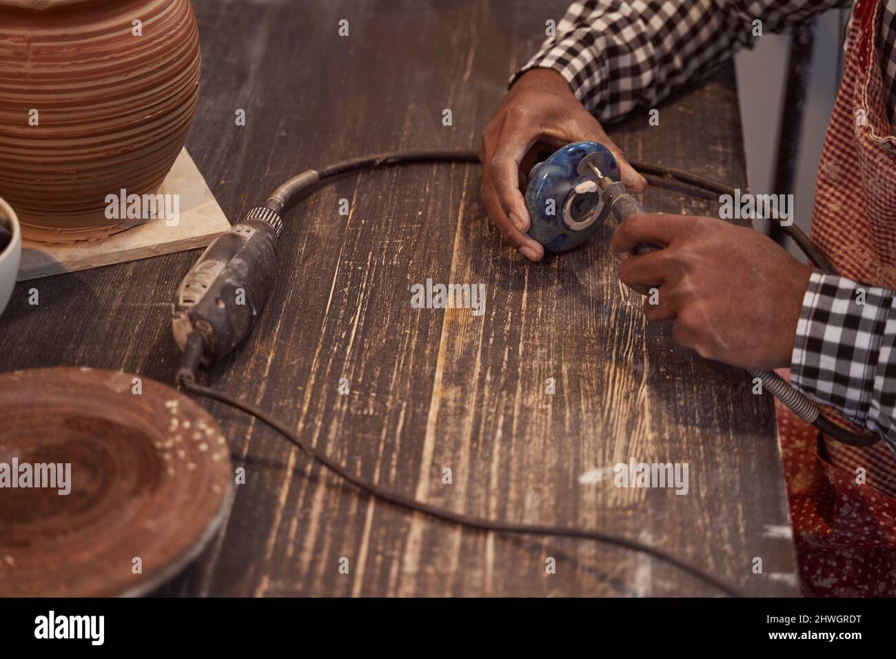 Potter removing drips of melted glaze off pottery surface Stock Photo ...