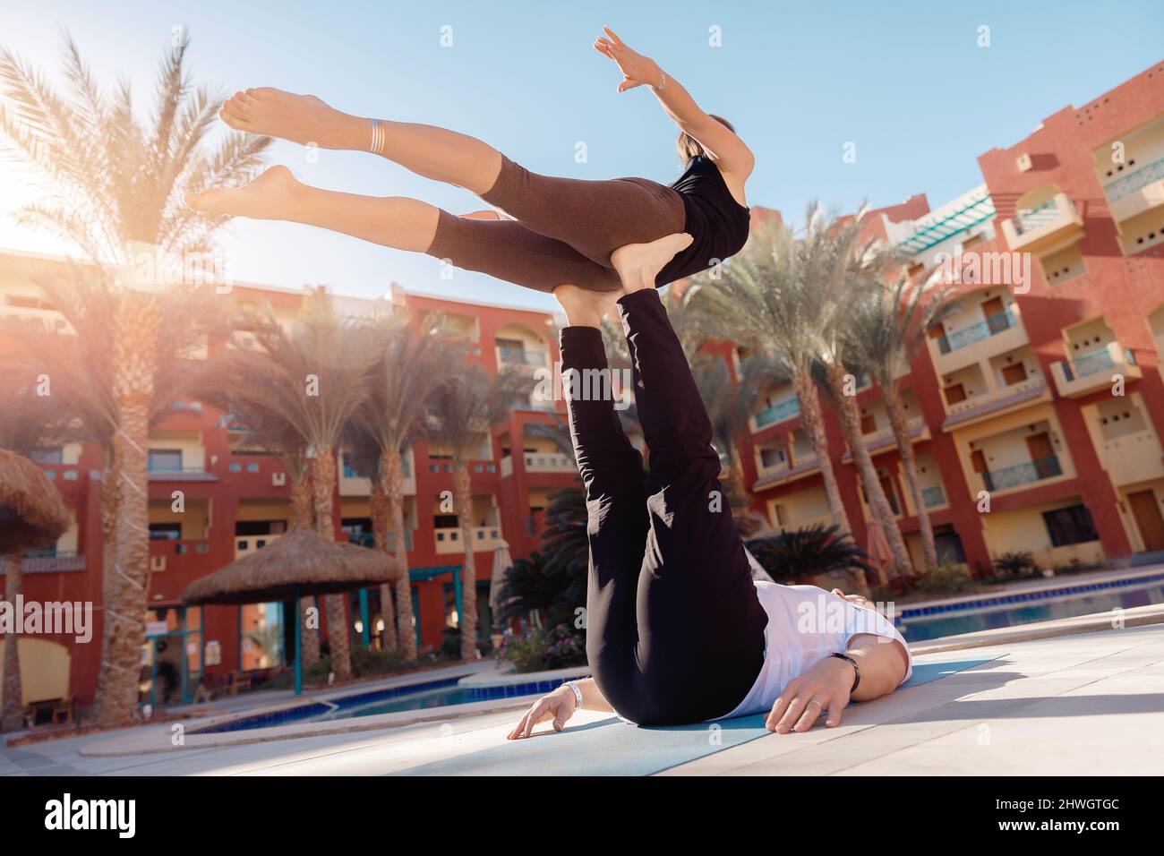 Couple lover young woman and man doing asana yoga background swimming ...