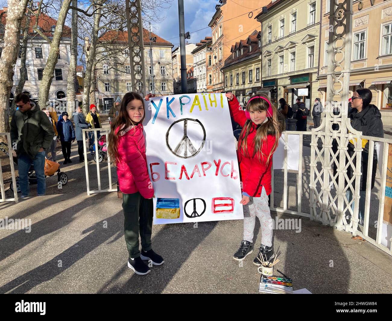 Two teenage girls with political banner Ukraine Belarus peace symbol ...