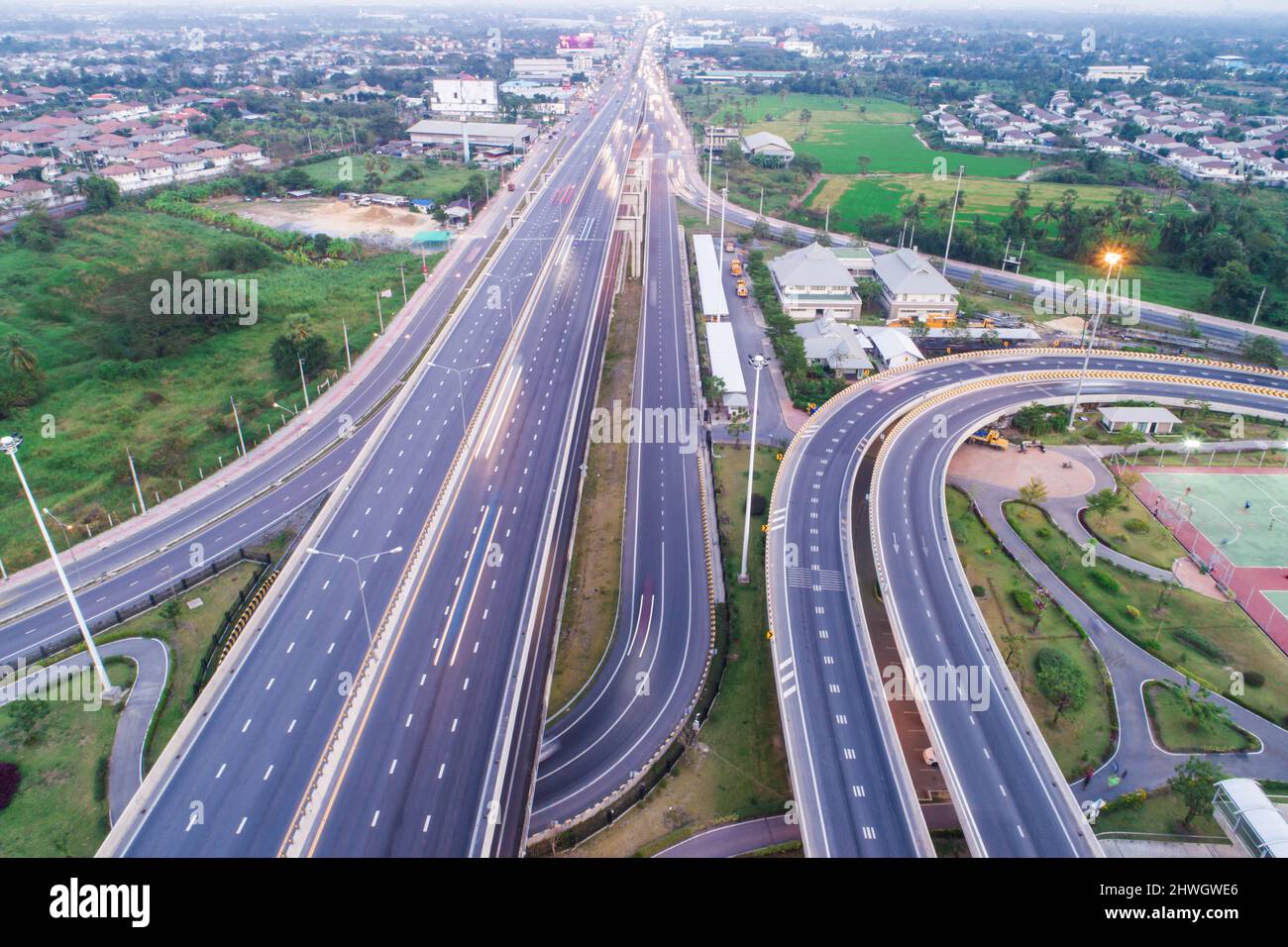 City transport road with vehicle movement surround by village aerial ...