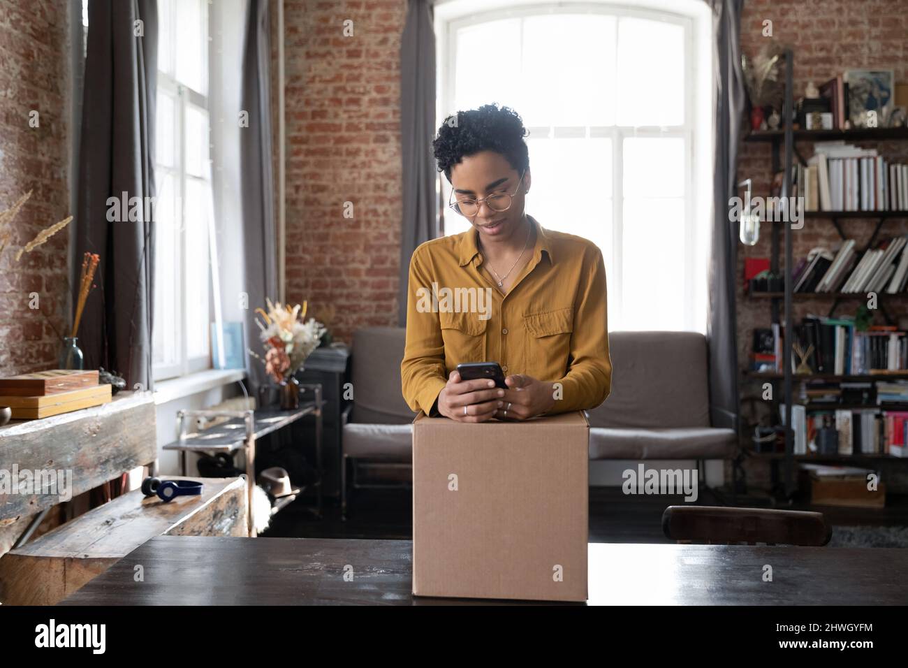 Positive African customer woman receiving purchase from internet shop ...