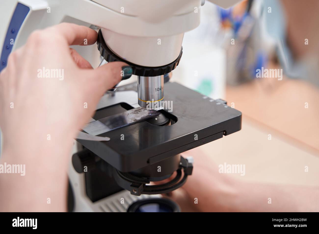 Glass with material for research on microscope Stock Photo - Alamy