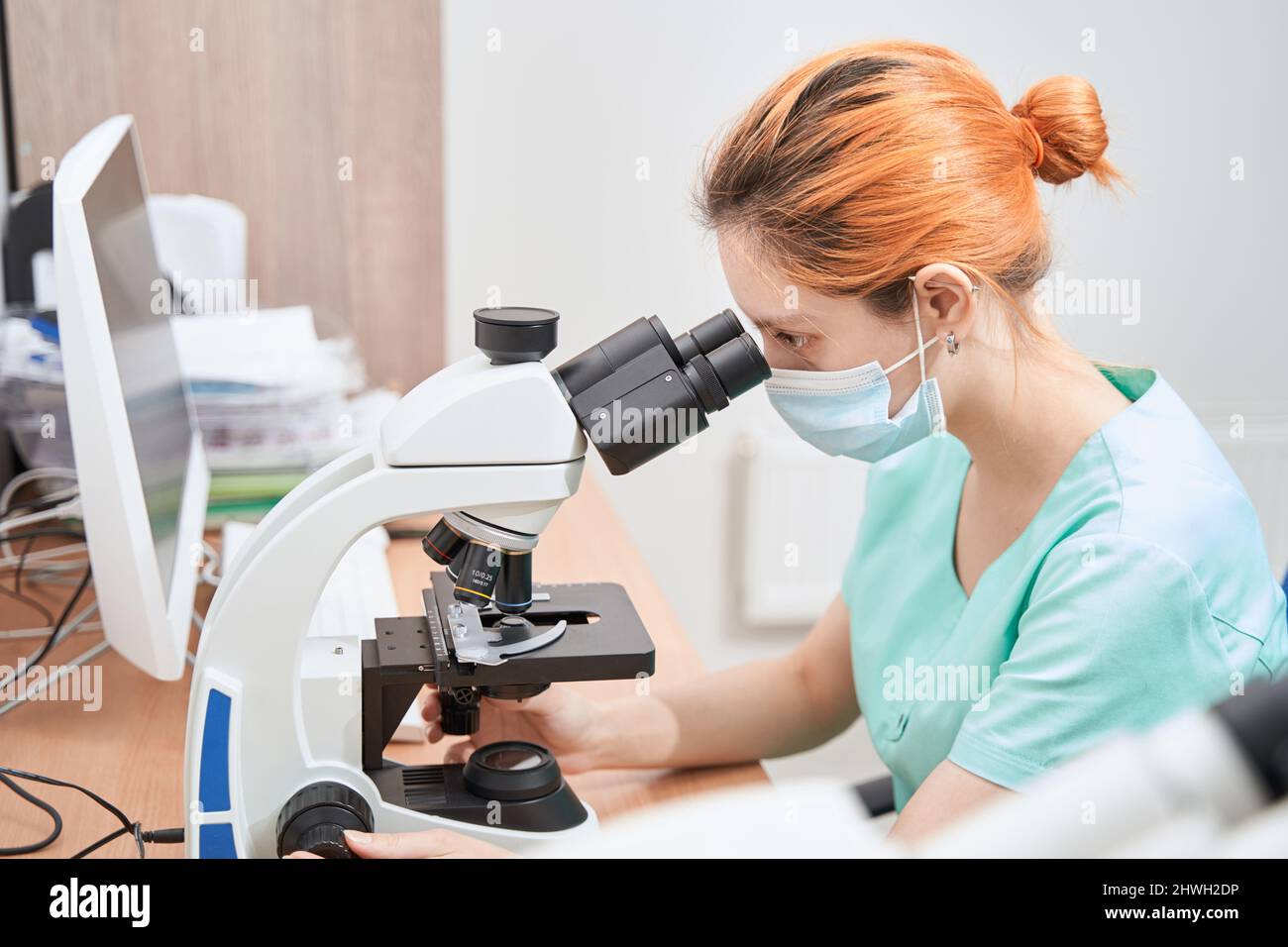Nurse working in the laboratory with microscope Stock Photo - Alamy