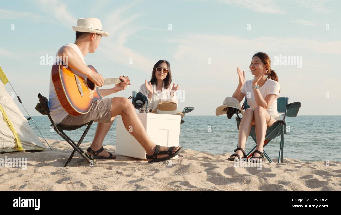 Happy friend have fun playing guitar and clap in camp they smiling ...