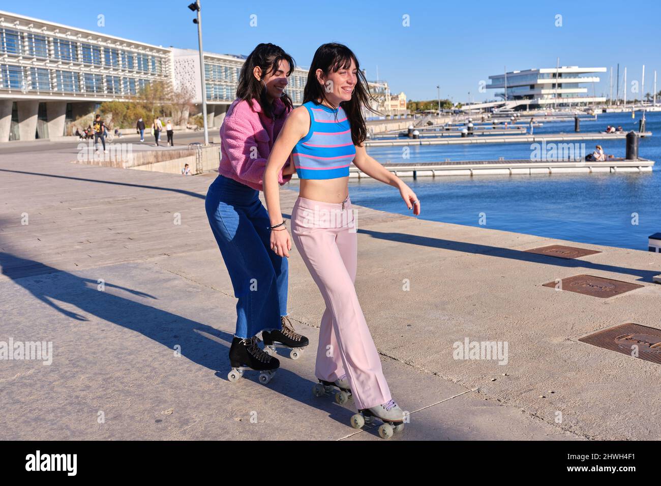 Two friends skating with classic skates in a promenade Stock Photo - Alamy
