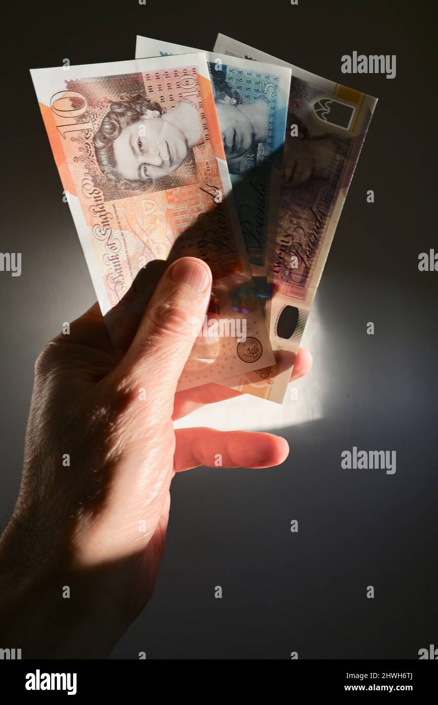 Close-up of senior man holding various pound notes Stock Photo - Alamy
