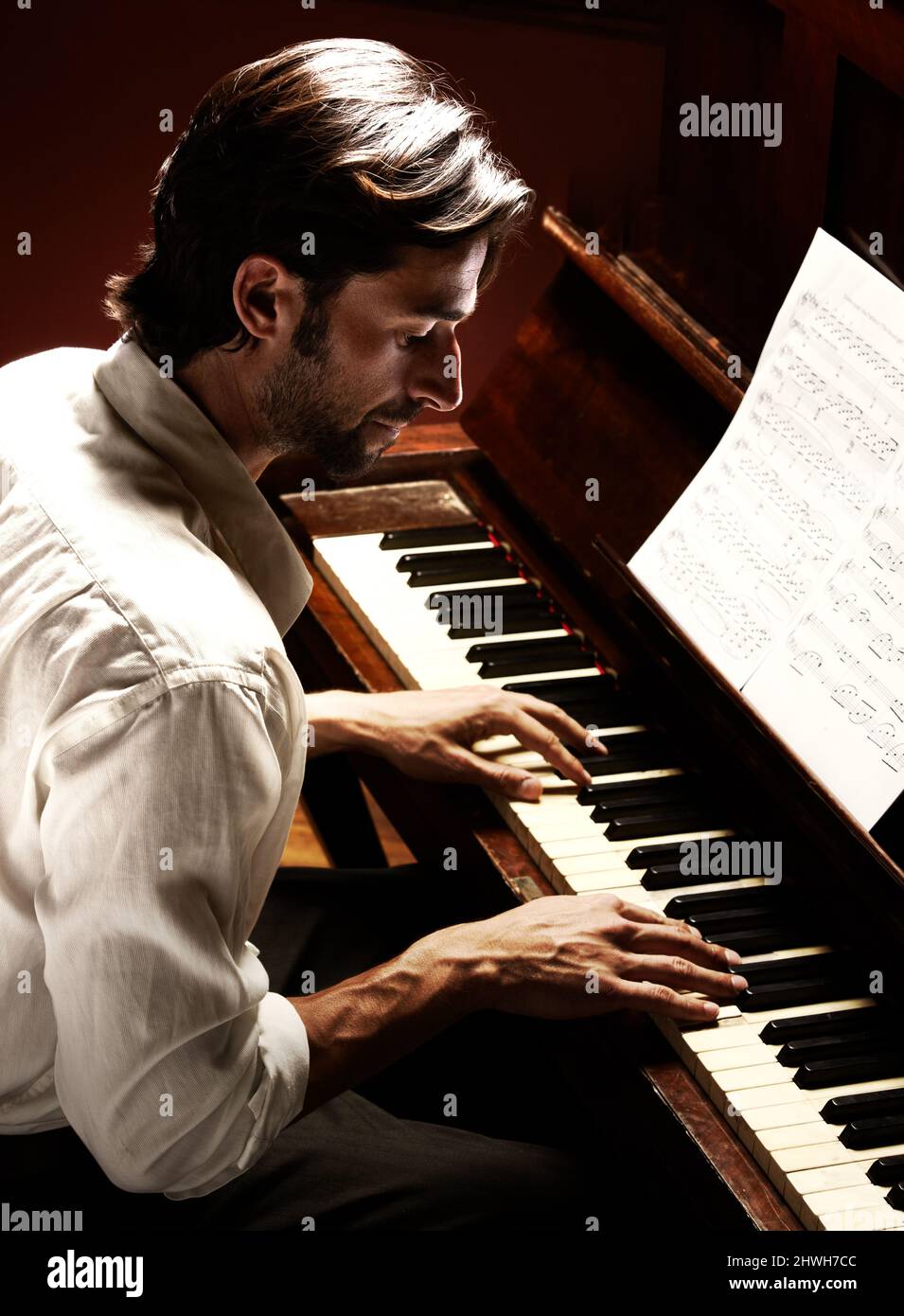 Making beautiful music. Profile of a handsome man playing the piano ...