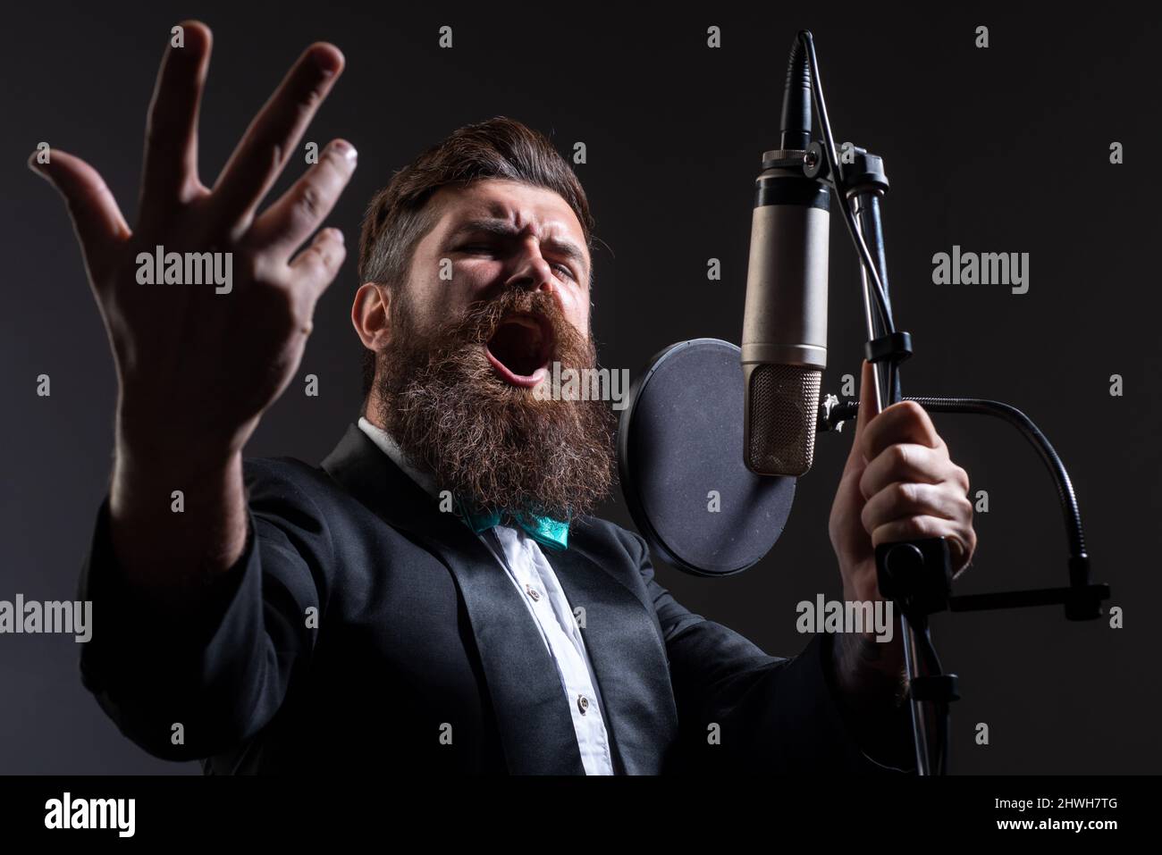 Classic singer in suit. Singer is performing a song with a microphone ...