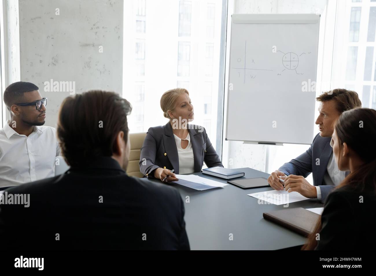 Focused serious diverse teammates brainstorming new ideas Stock Photo ...