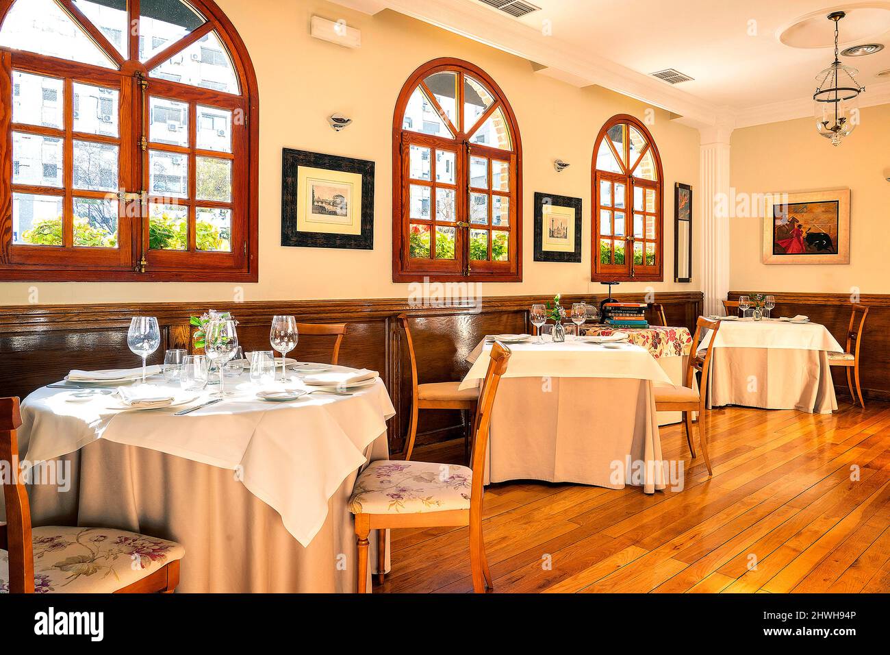 Interior view of an empty restaurant with tables set in a warm and ...
