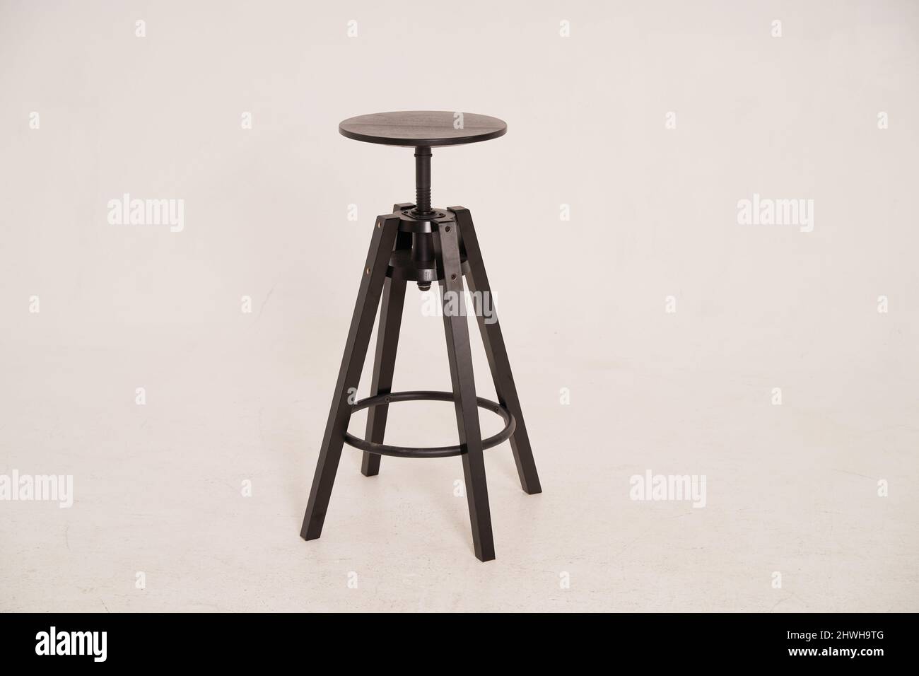 Black bar stool on legs on a light background Stock Photo - Alamy